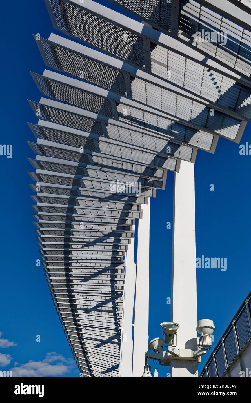 Brilliant white against a blue sky, a steel-panel arch soars above the ...