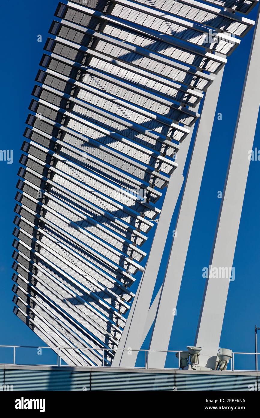 Brilliant white against a blue sky, a steel-panel arch soars above the ...