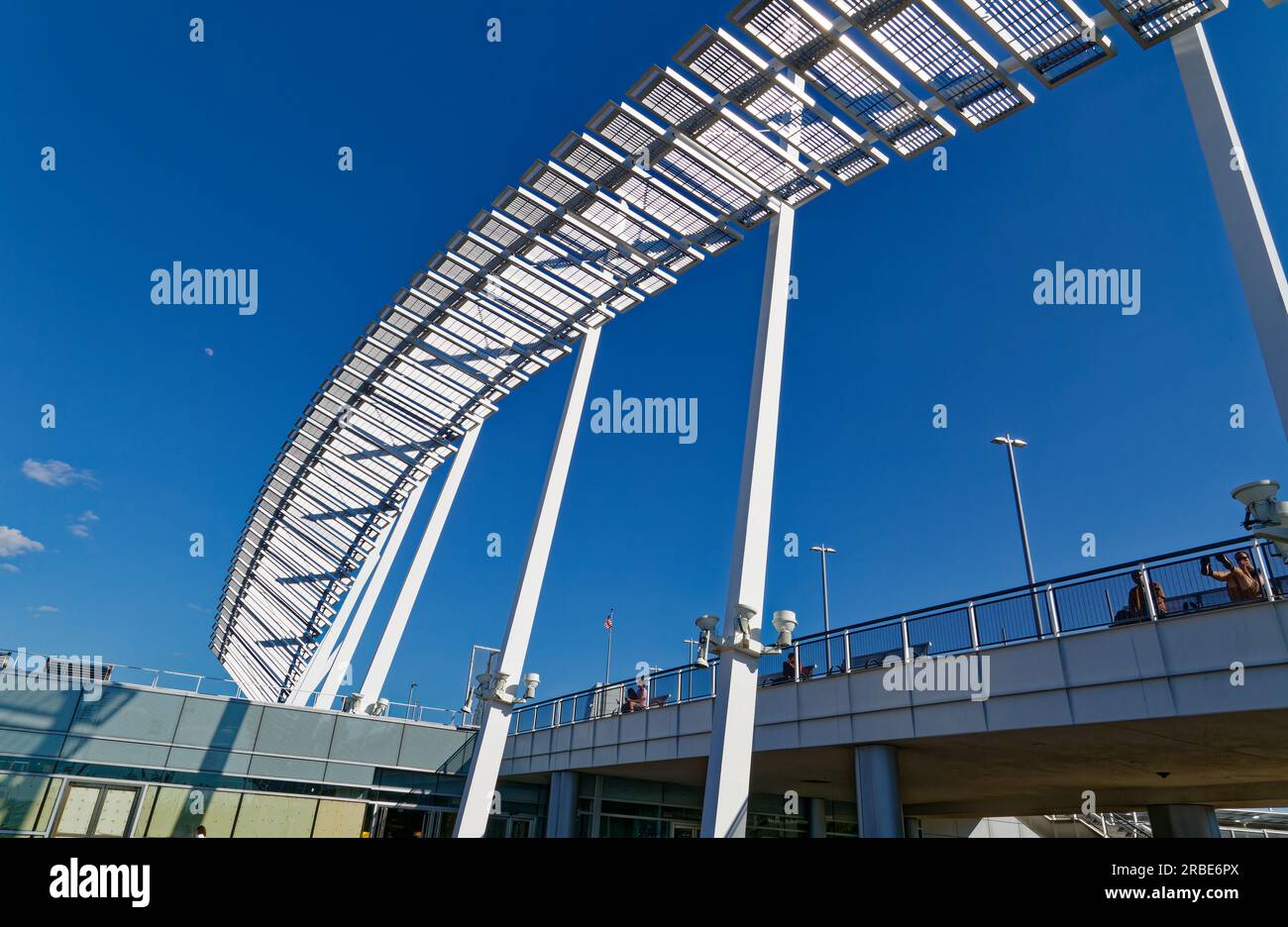 Brilliant white against a blue sky, a steel-panel arch soars above the ...