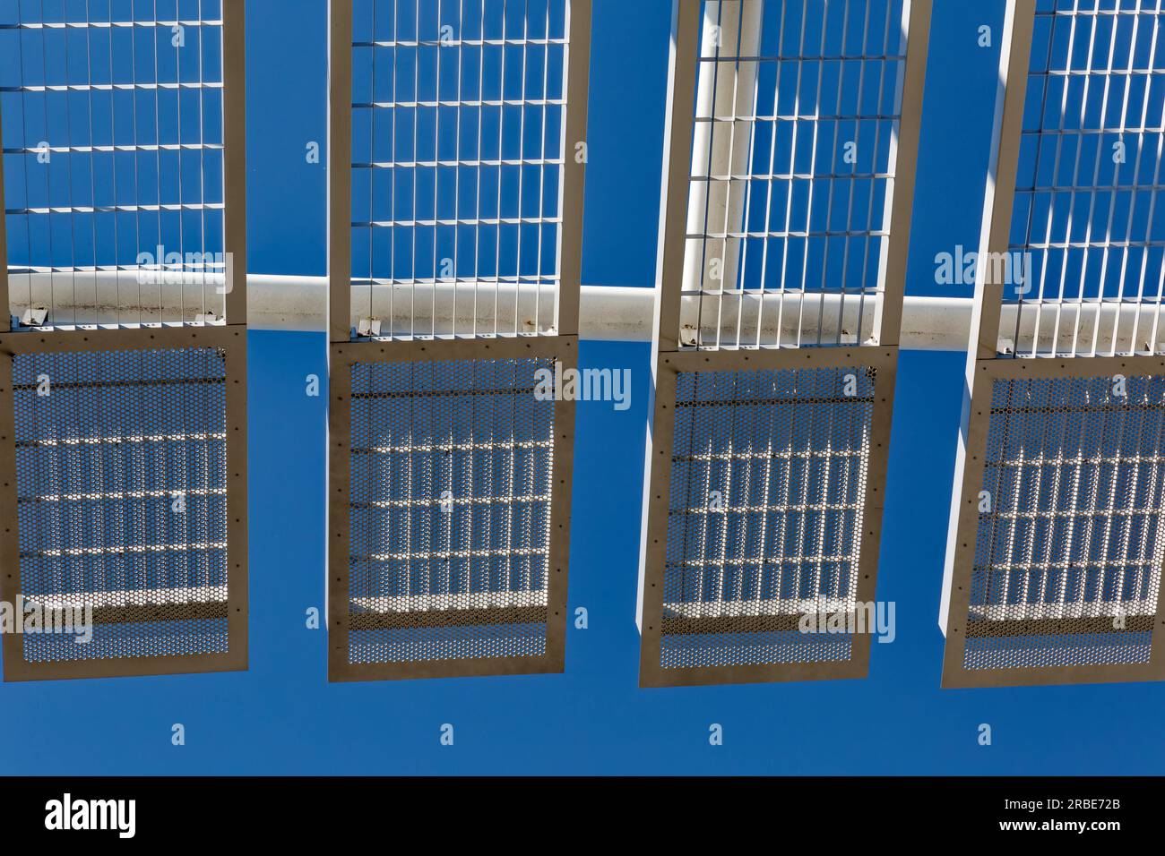 Brilliant white against a blue sky, a steel-panel arch soars above the ...