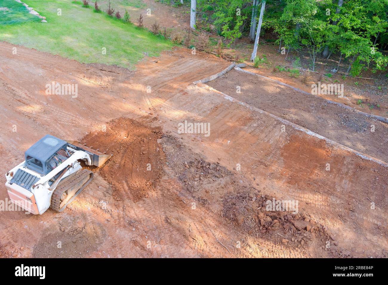 When preparing an area for construction, tractor is used to move earth ...