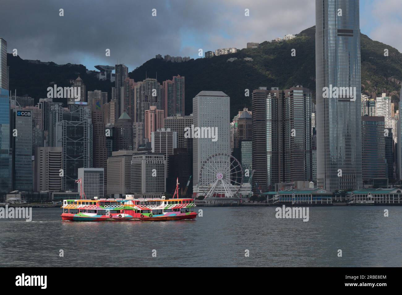 View of Central Waterfront (in shadow) with colourful Star Ferry crossing Victoria Harbour, from ...