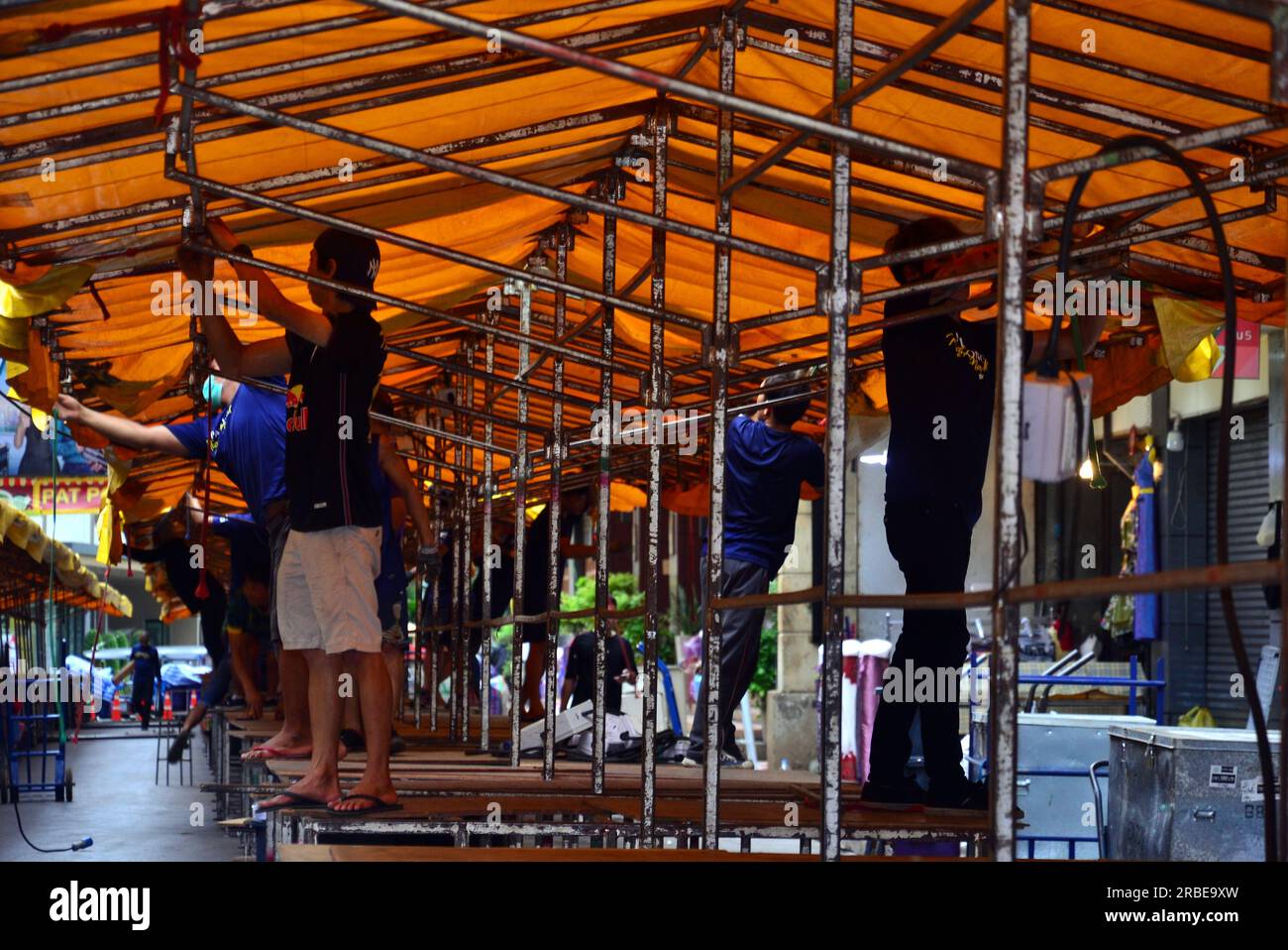 Young men assemble the stall structures of Patong Night Market, on Patpong Road 1, in Silom ...