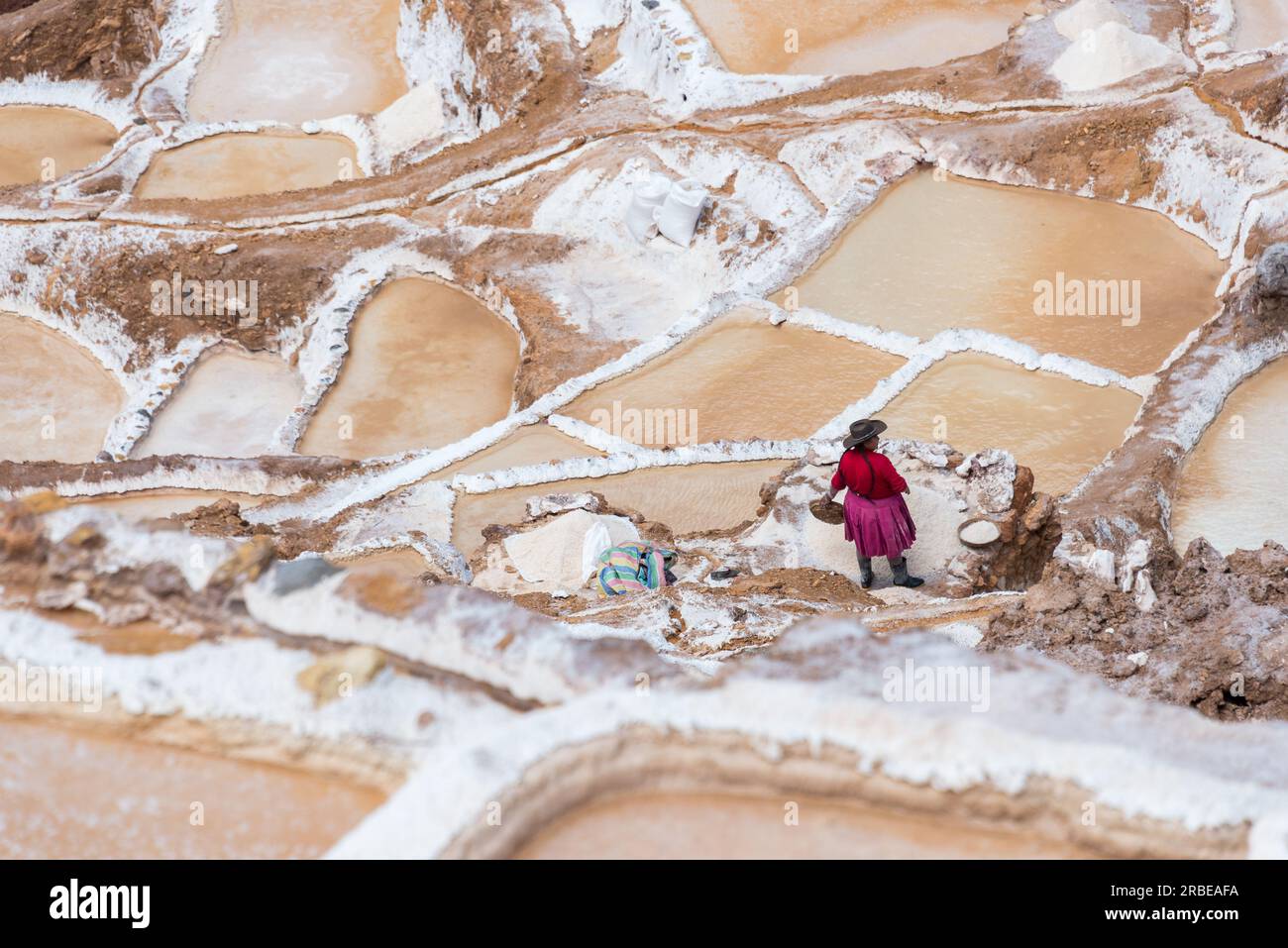 Woman extracting salt at Maras Peru Stock Photo - Alamy