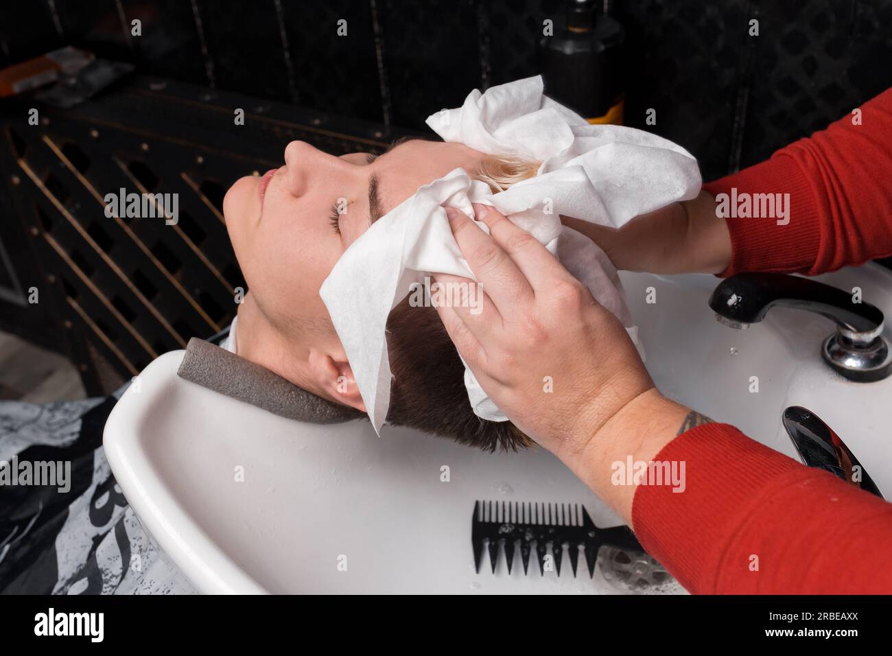 The hands of a professional male hairdresser wipe, the hair on the head ...