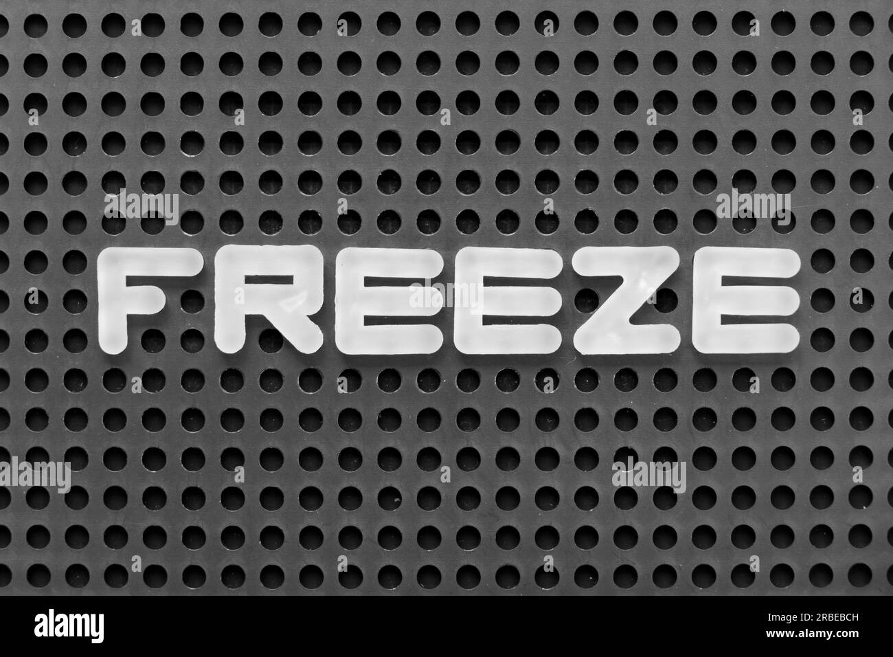White alphabet letter in word freeze on black pegboard background Stock ...
