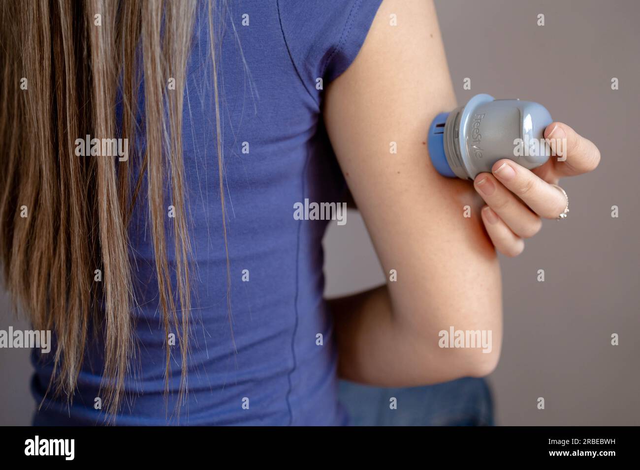 Close-up of girl applying flash glucose monitoring patch on her arm ...