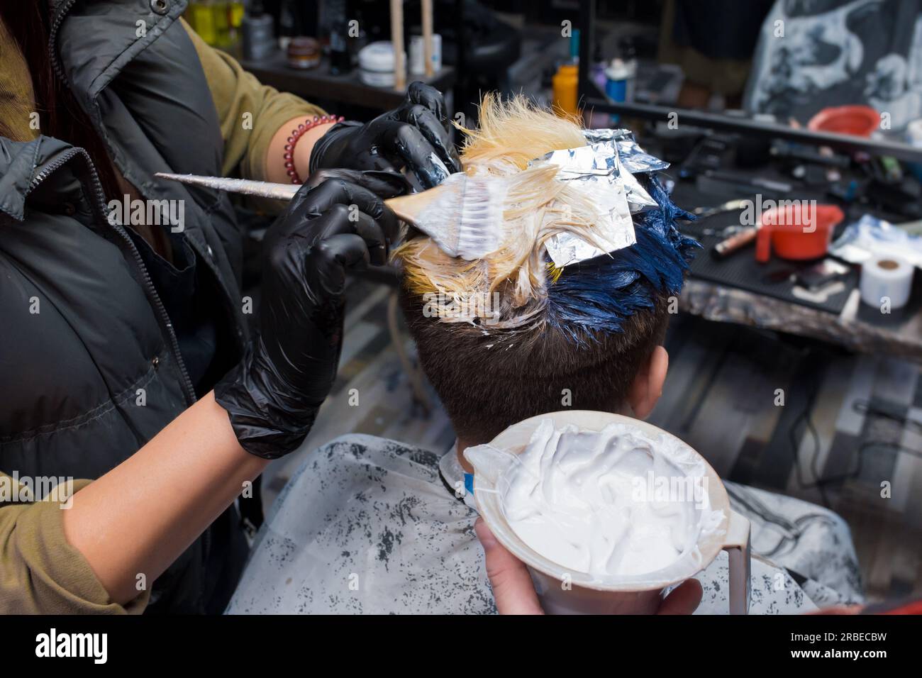 Hands of a professional barber woman wearing gloves in the process of ...