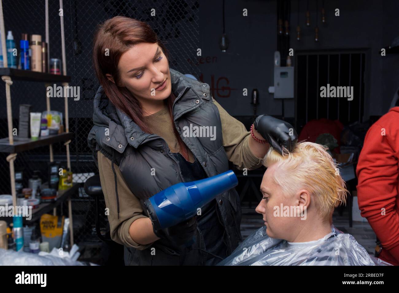 Cute beautiful adult girl caucasian professional barber drying hair for ...