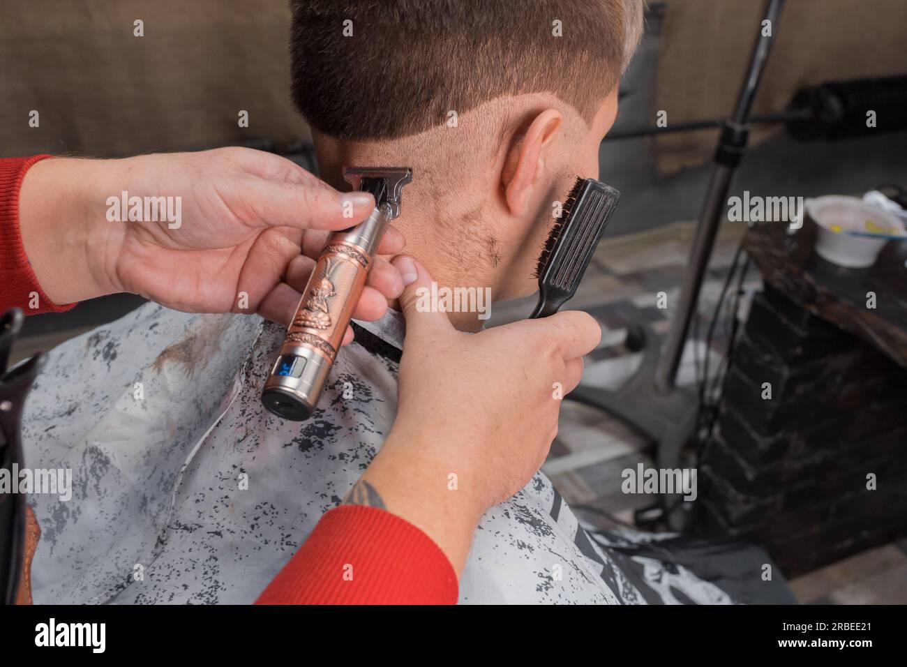 The hands of a man of an experienced hairdresser hold a brush for hair ...