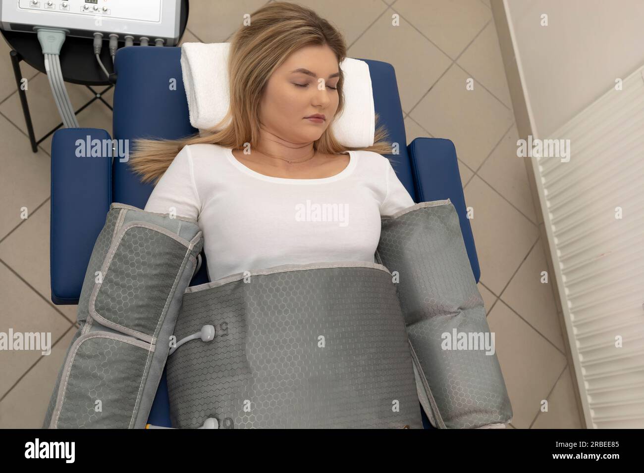 Top view pressure therapy procedure. Woman lying in massaging suit in ...