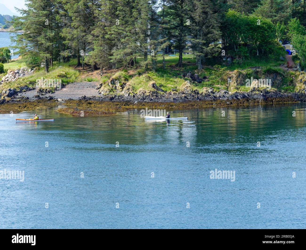 Two people in kayaks at Oban Bay pass between Oban and Kerrera, Inner ...