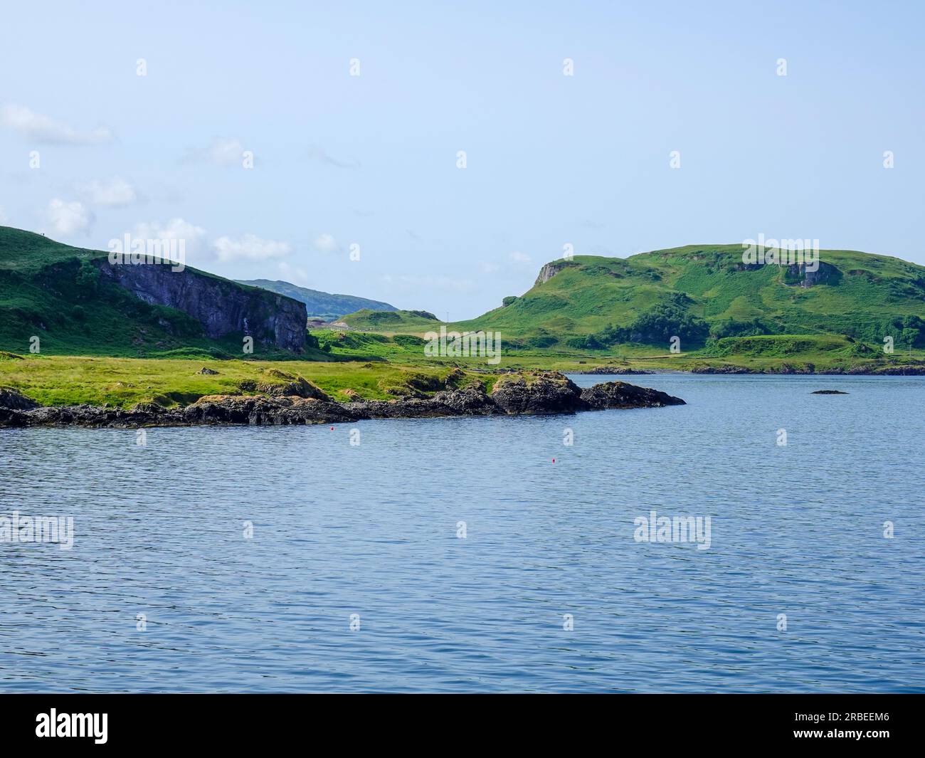 Green hills, rocky coast, grass covered Isle of Kerrera, Inner Hebrides ...