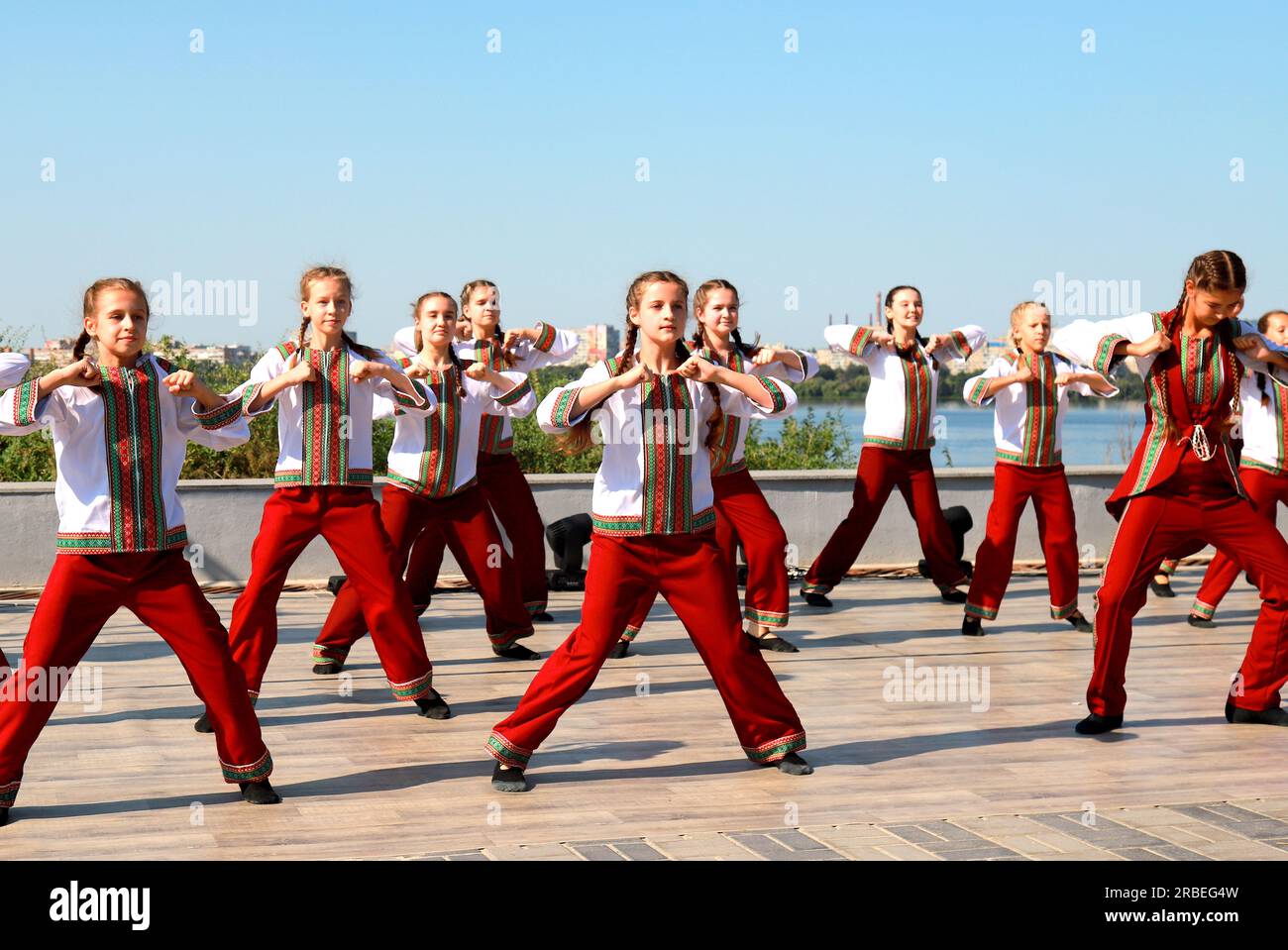 Young girls and boys dance national Ukrainian dance in folk costumes ...