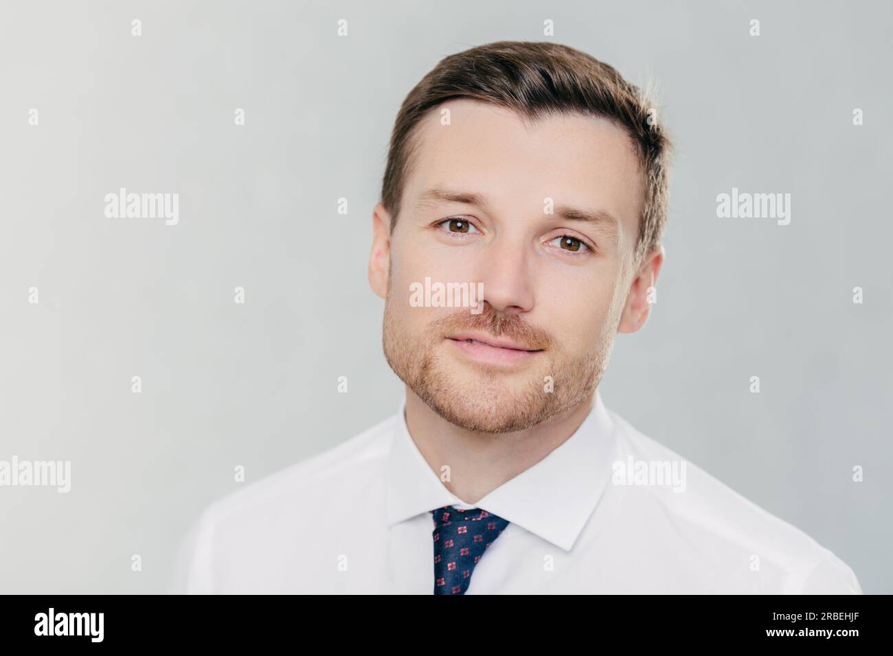 Self-assured businessman, prosperous owner, dressed elegantly, stands ...