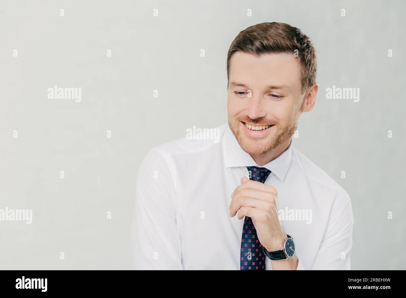 Professional office manager giggles positively, dressed in white shirt ...