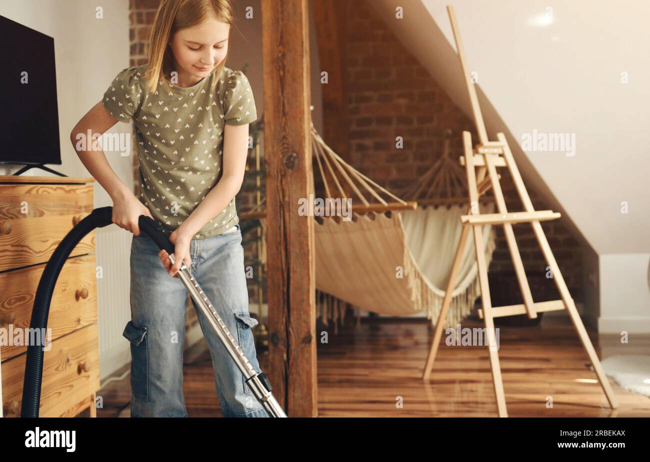 Girl child cleaning carpet with vacuum cleaner from dust at home ...