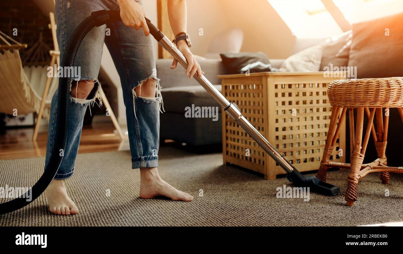 Girl cleaning carpet with vacuum cleaner from dust at home. Woman ...
