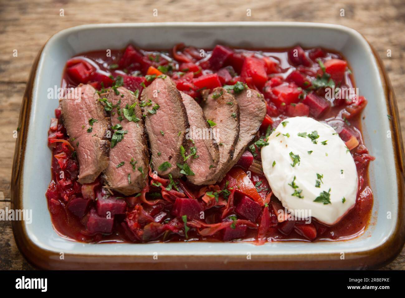 Homemade Borscht soup served with pan fried venison slices from a roe ...