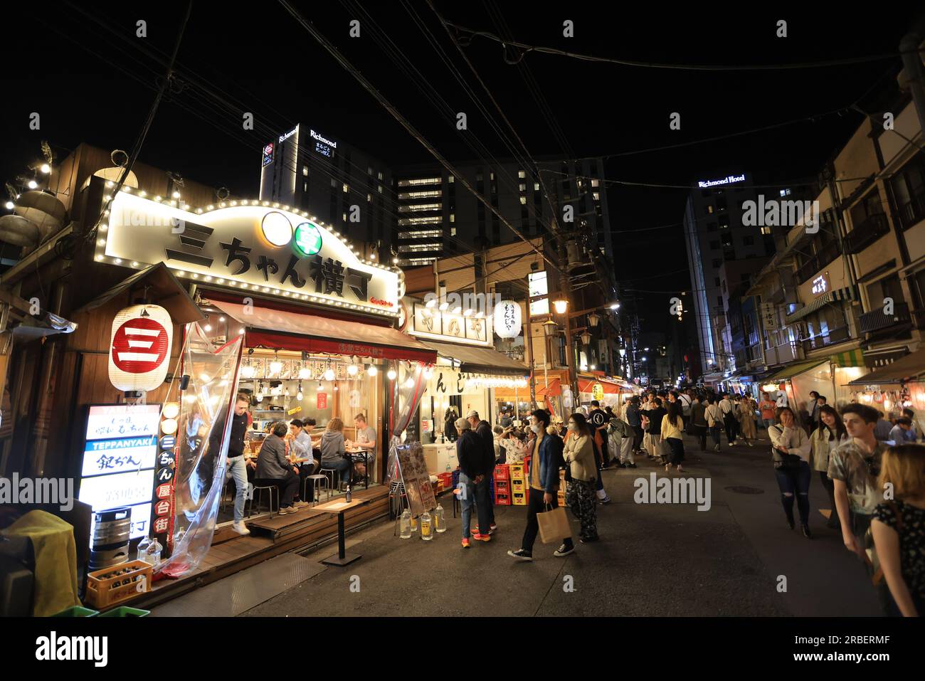 visitors enjoy the street food at hobby street at night. one of ...