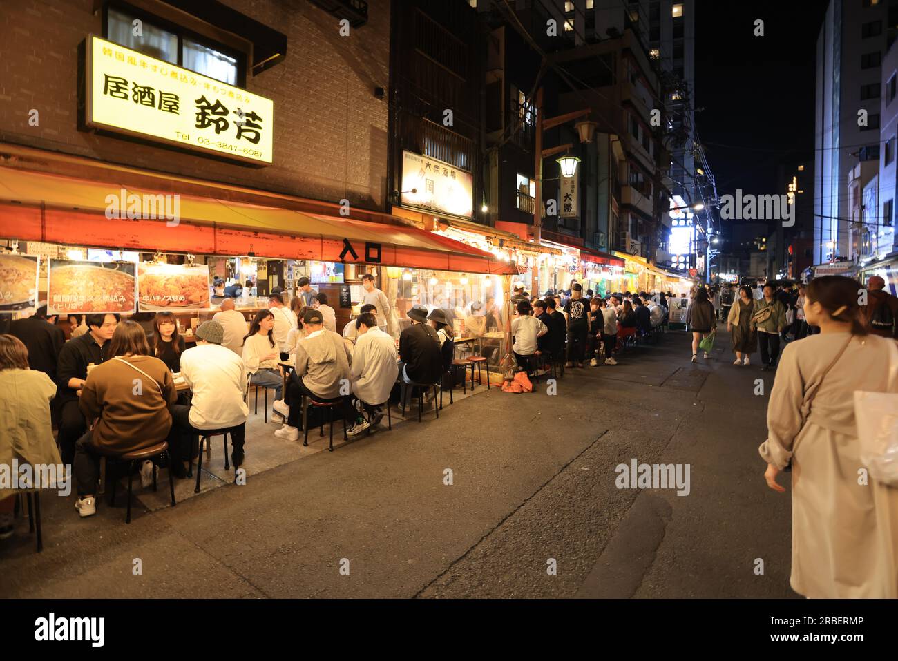 visitors enjoy the street food at hobby street at night. one of ...