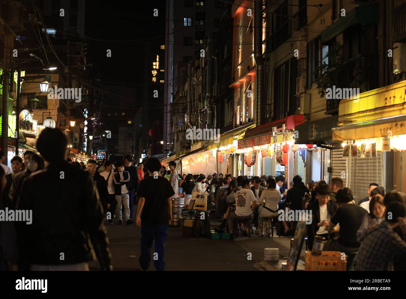 visitors enjoy the street food at hobby street at night. one of ...