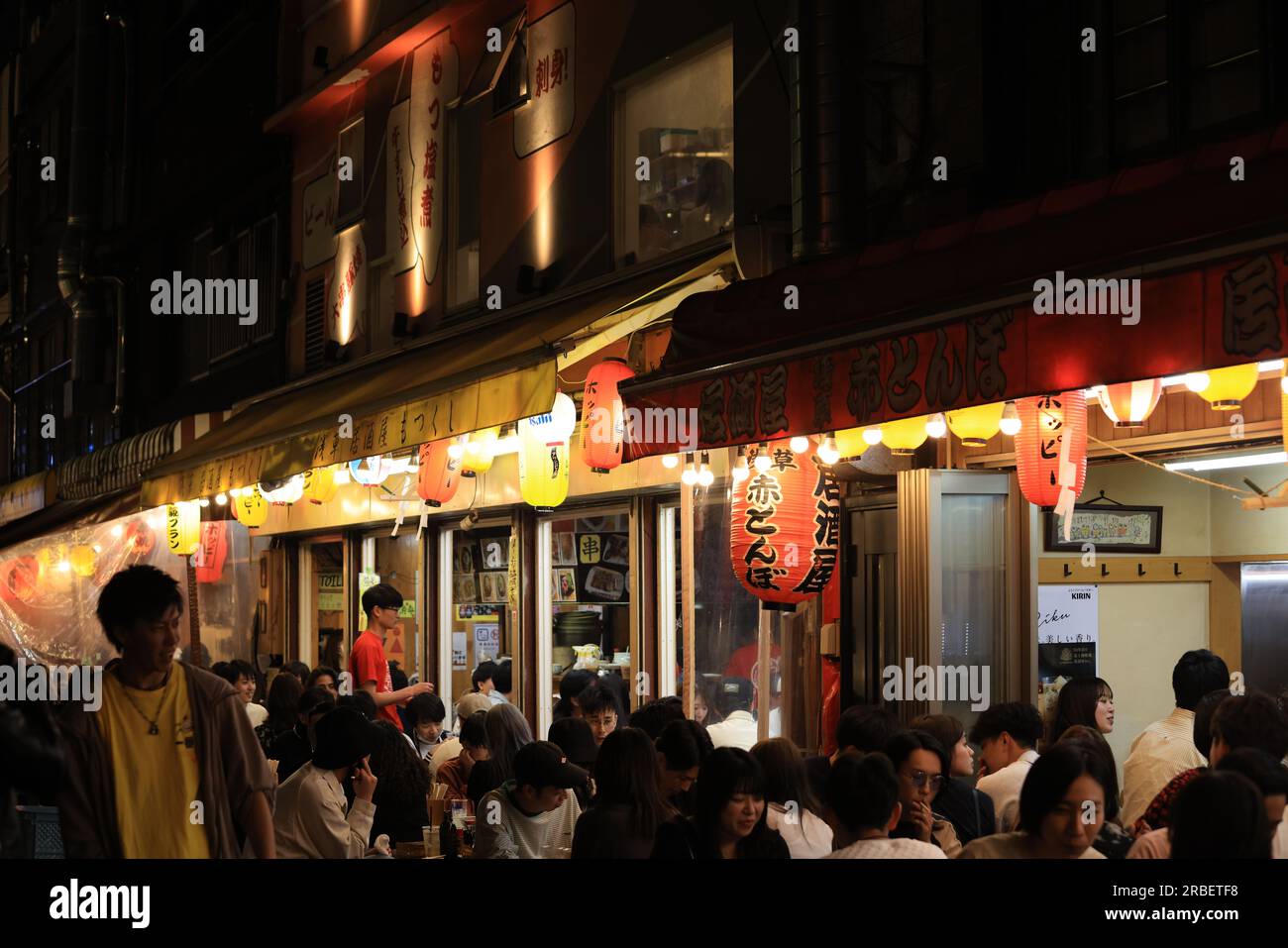 visitors enjoy the street food at hobby street at night. one of ...