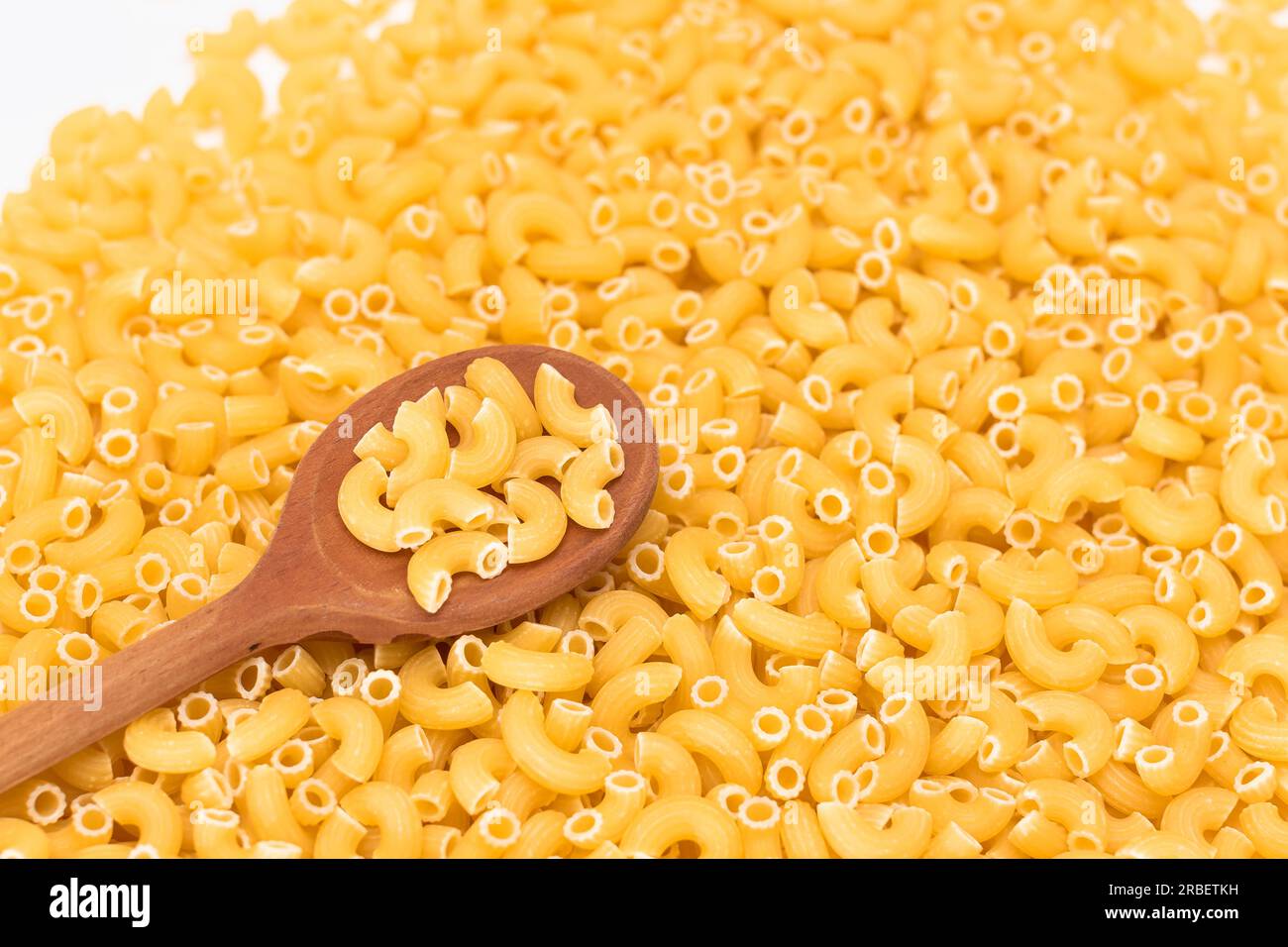 Uncooked Chifferi Rigati Pasta Background with Wooden Spoon. Fat and ...