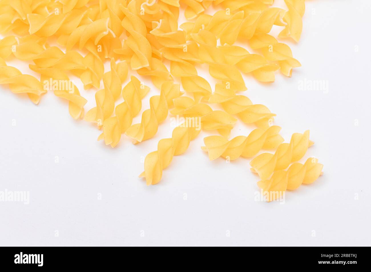 A Heap of Uncooked Fusilli Pasta Scattered on White Table. Raw and Dry ...