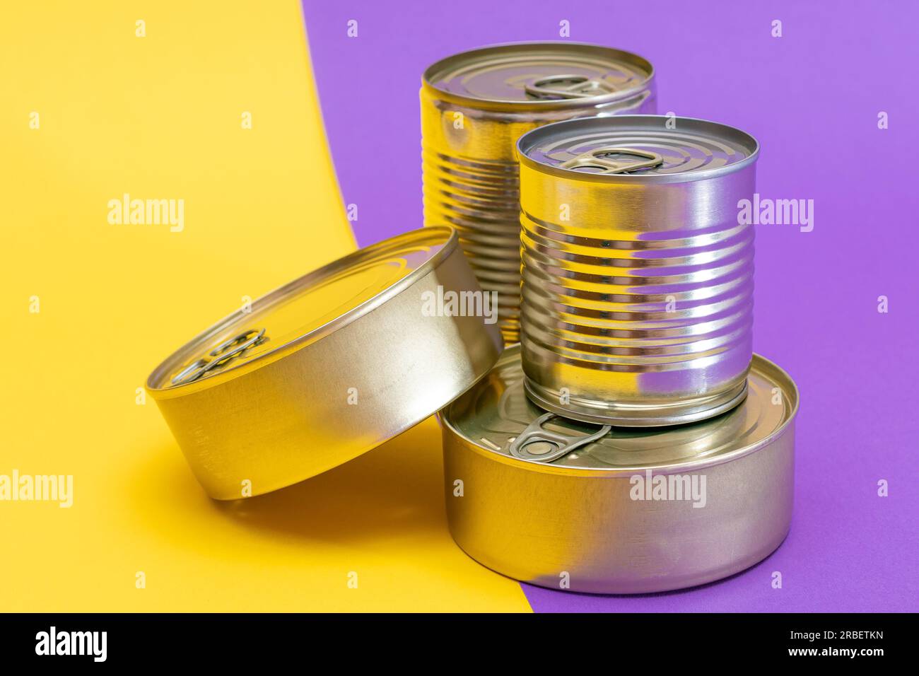 A Group of Stacked Tin Cans with Blank Edges on Split Yellow and Violet ...