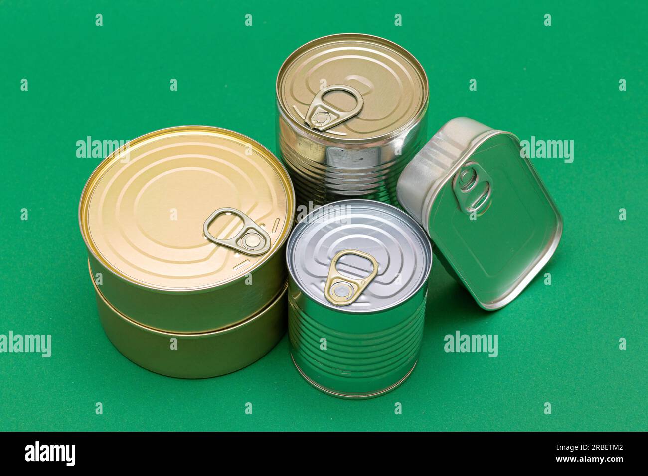 A Group of Stacked Tin Cans with Blank Edges on Green Background ...