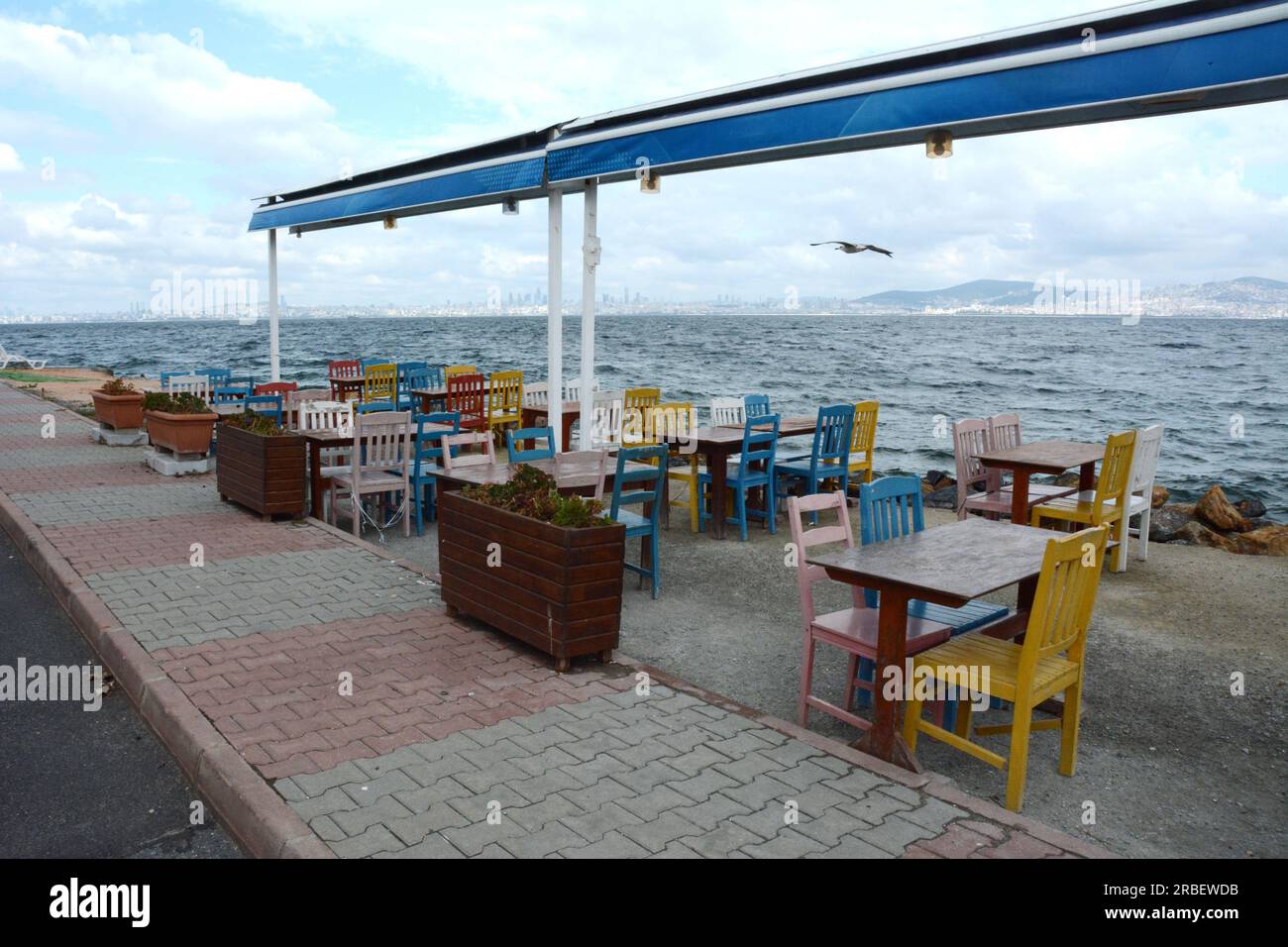 Tables and chairs at a seaside cafe on the island of Burgazada, in the ...