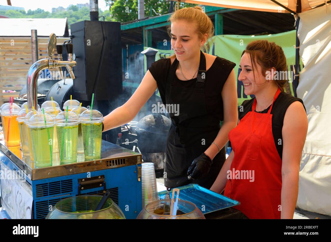 Street barmaids working pouring beer in a glasses for customers ...