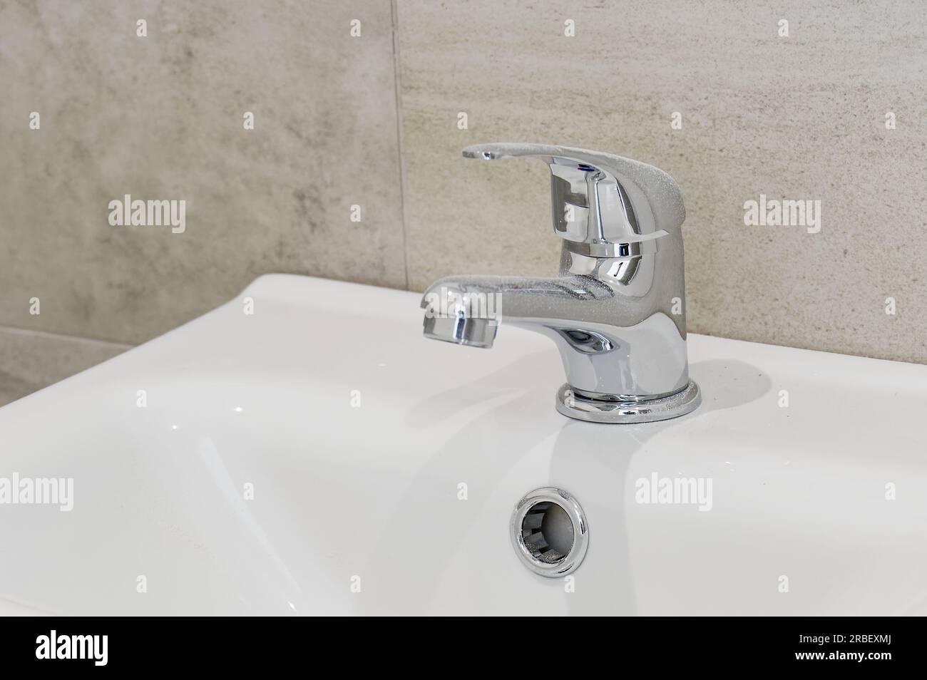 White basin with chrome mixer tap on vanity unit Stock Photo - Alamy