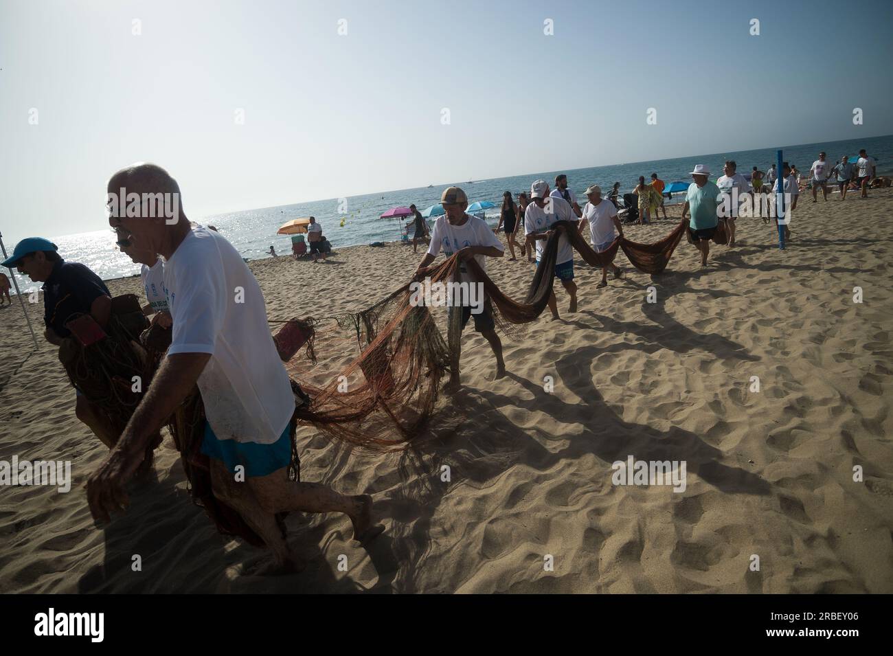 Locals are seen carrying large nets on the beach after taking part in ...