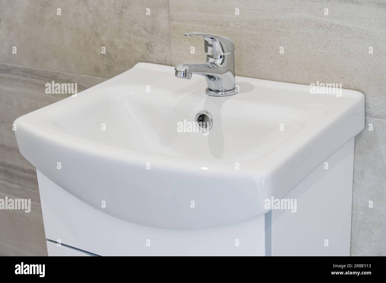 White basin with chrome mixer tap on vanity unit Stock Photo - Alamy