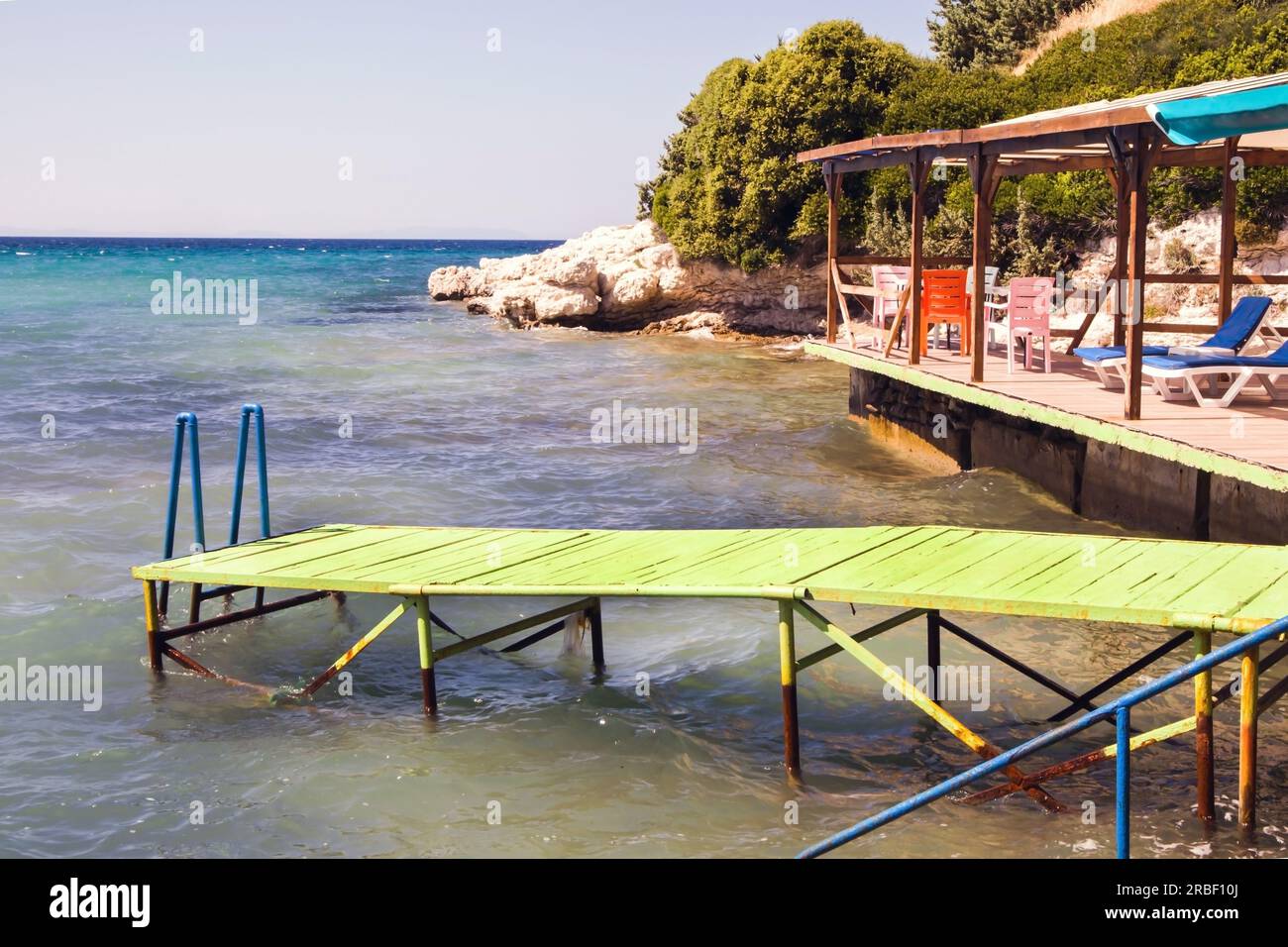 Beach cafe on the sea with tables, sun loungers, walking platform and ...