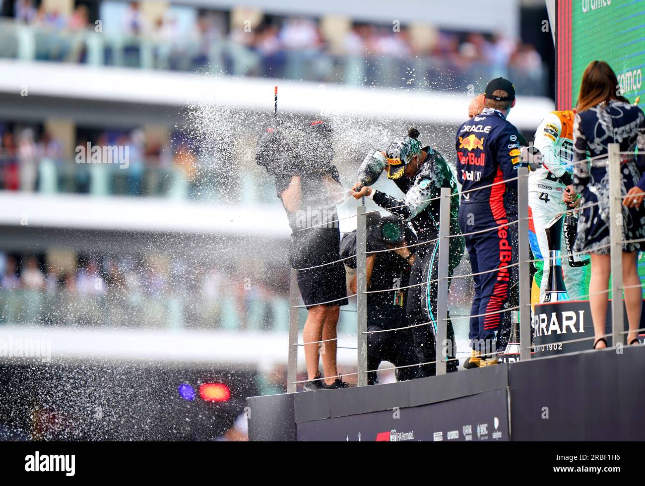 Mercedes' Lewis Hamilton celebrates on the podium by spraying champagne ...