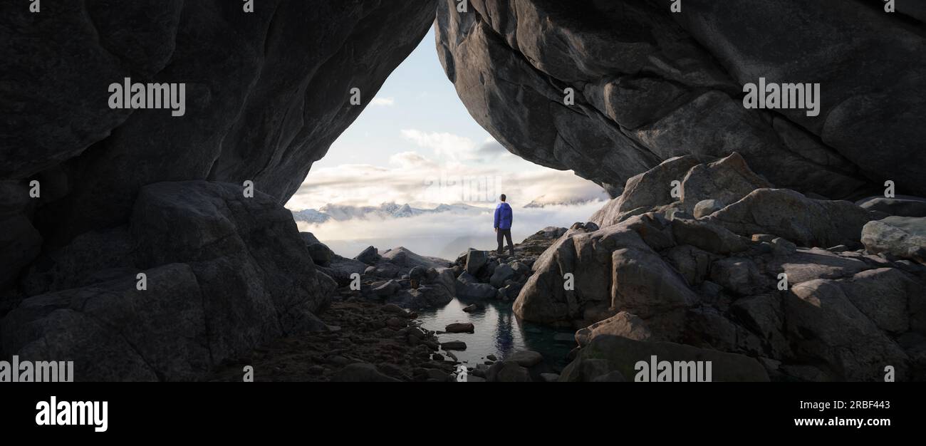 Adventurous Man Standing in cave on top of Mountain. Extreme Adventure ...