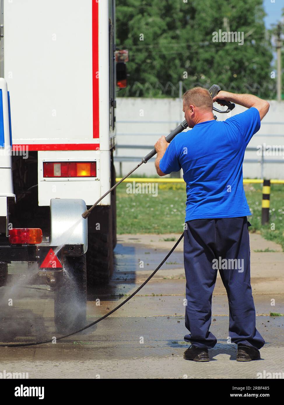 Car wash for heavy vehicles and trucks. Male car wash worker washes a ...
