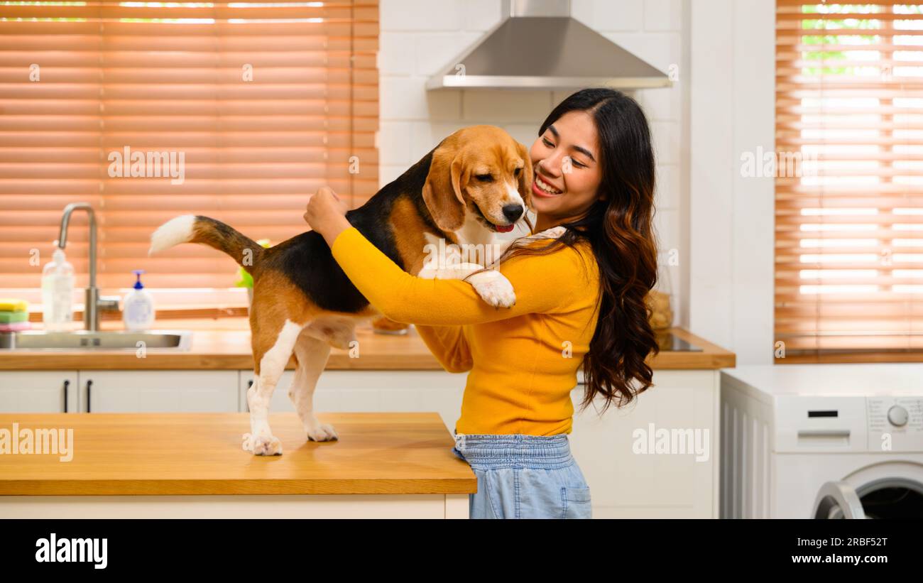 A woman is shown in a friendly interaction with her dog, a playful ...