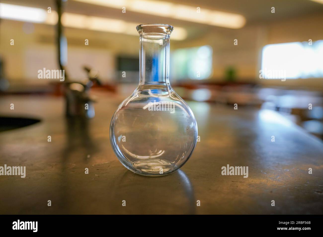 flask on a black resin table with a high school science room background ...