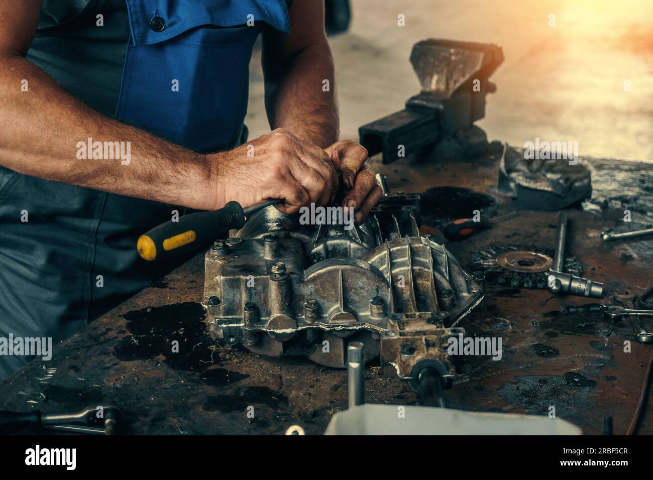 Mechanic repairs gearbox on metal workbench in car repair shop. Auto ...