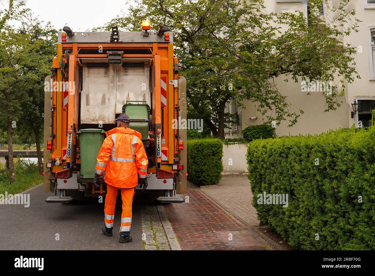 Garbage truck loads tanks, rear view. A specialized car removes garbage ...