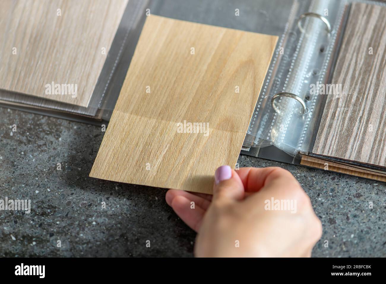 Samples of chipboard. A close-up woman's hand takes out a chipboard ...