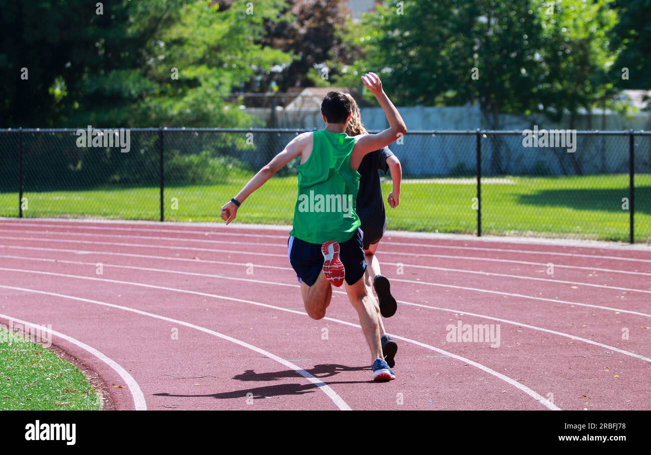 Rear view of a boy throwing chasing his friend to throw a water balloon ...