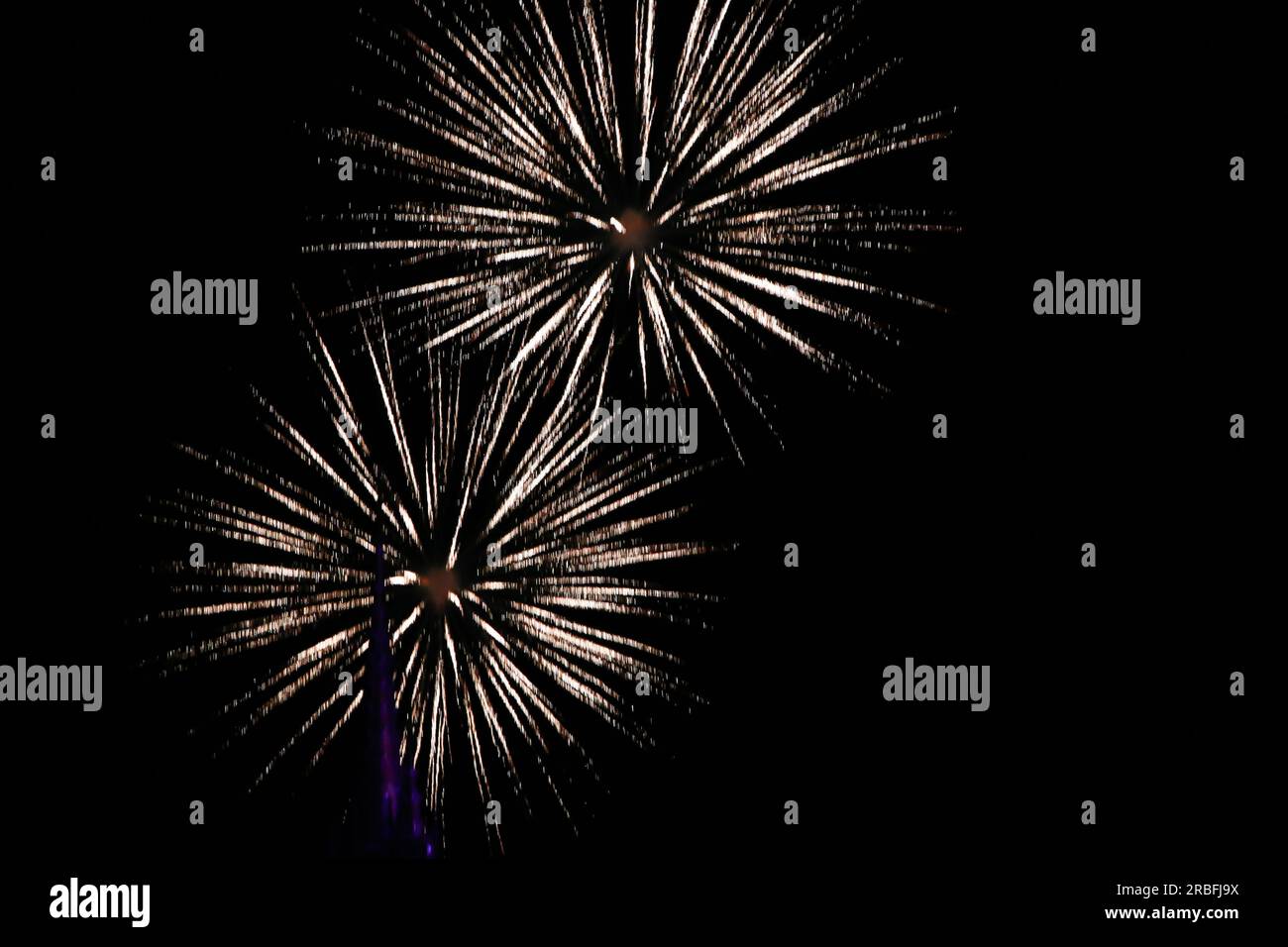Large white fireorks display behind the top of a building during a ...