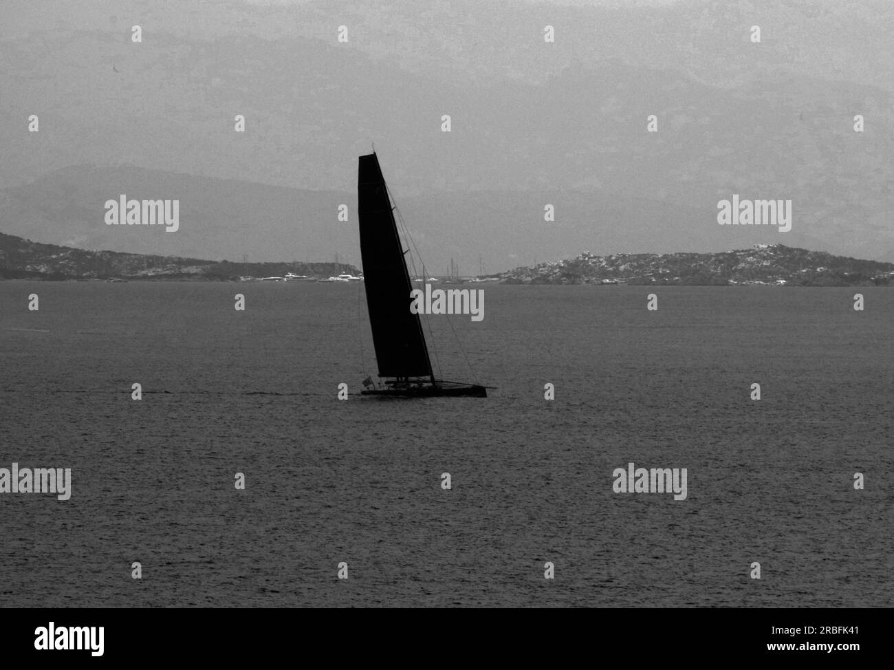 Black sailboat in transit in front of Palau, Sardinia, Italy Stock ...