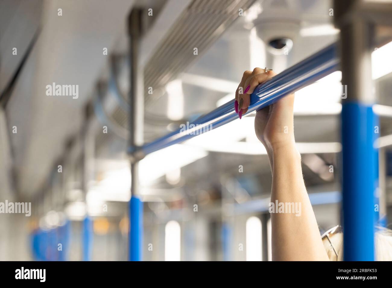 Woman holding hand on handrail in subway car. hand holding the railing ...