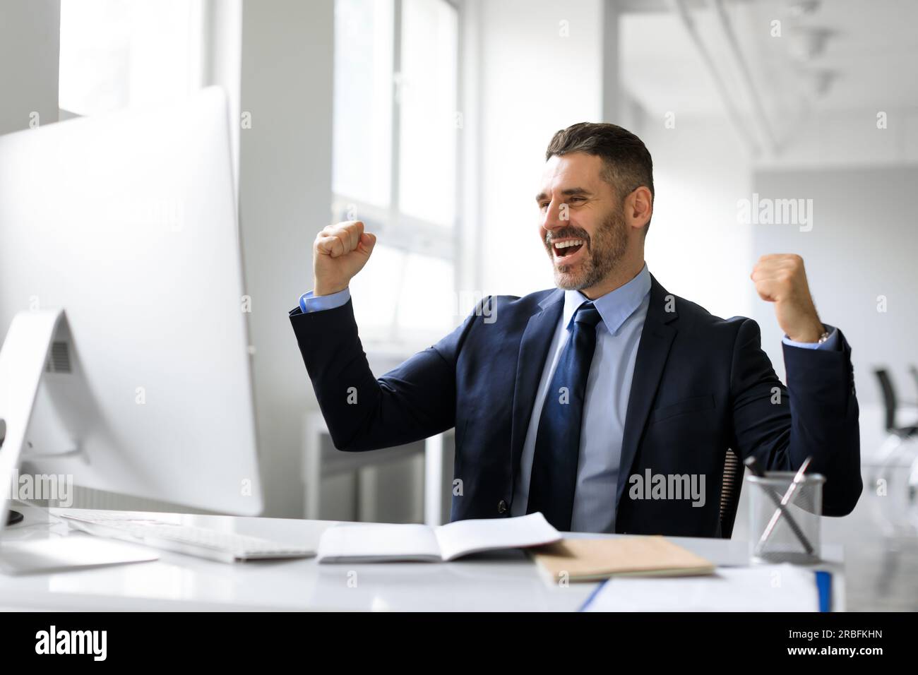 Excited middle aged businessman celebrating success in front of ...